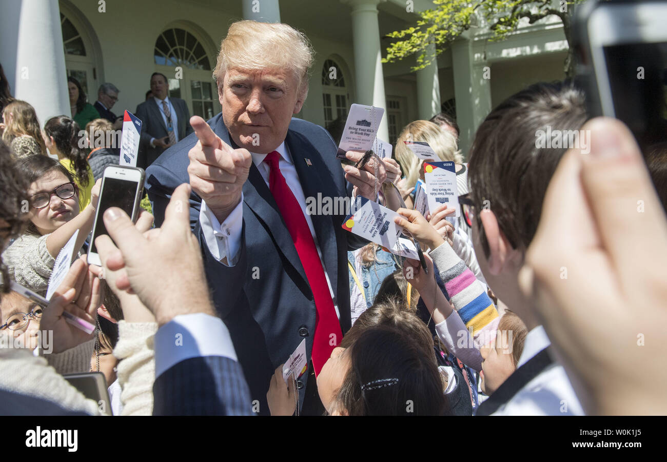 President Donald Trump signs autographs as he meets with children on ...
