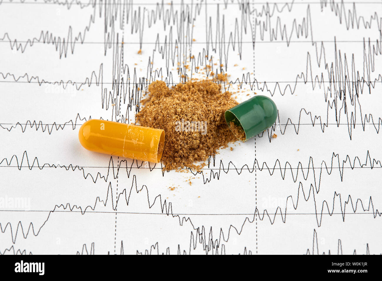 Opened green and yellow capsule with medicine on EKG graph Stock Photo ...