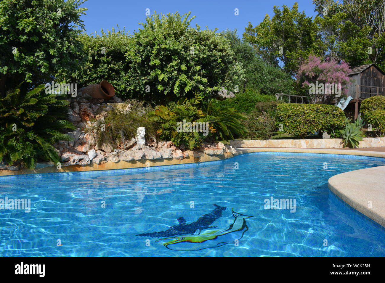 Swimming pool with a rockery in a Mediterranean garden in the summer ...