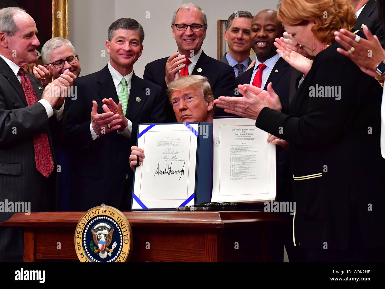 President Donald Trump holds up S. 2155 - Economic Growth, Regulatory ...