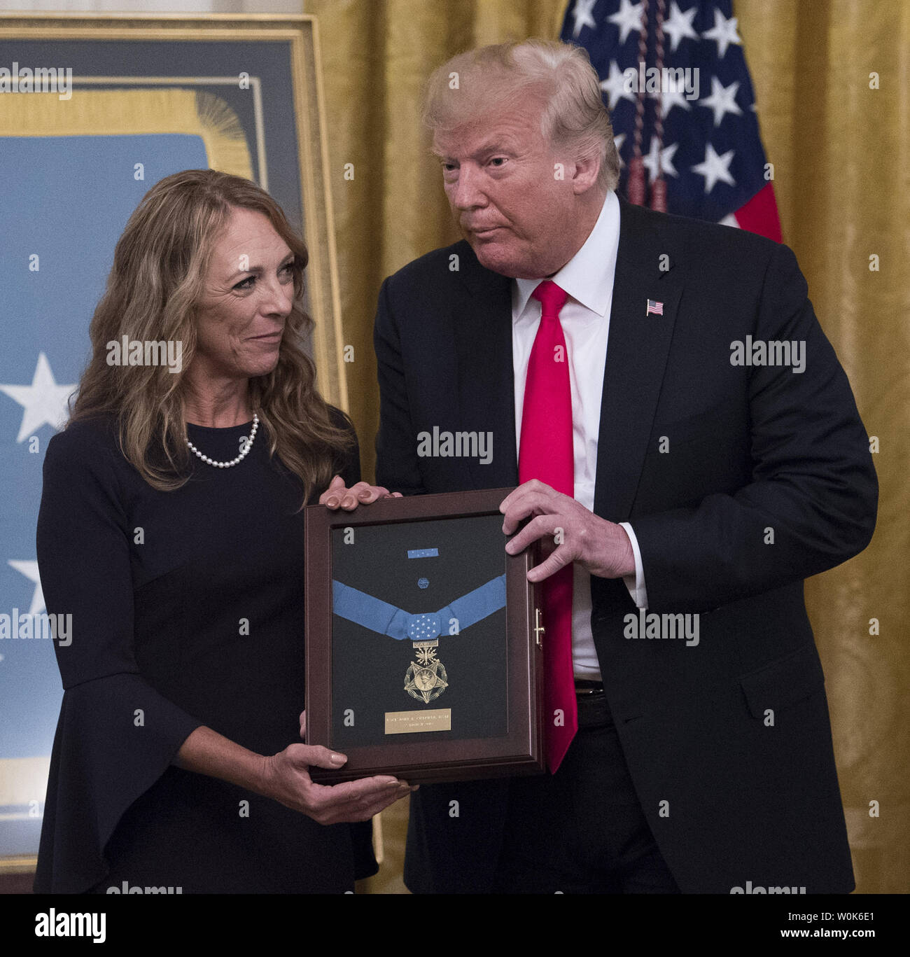 President Donald Trump presents Valerie Chapman, the widow of Air Force Tech Sgt. John Chapman ...