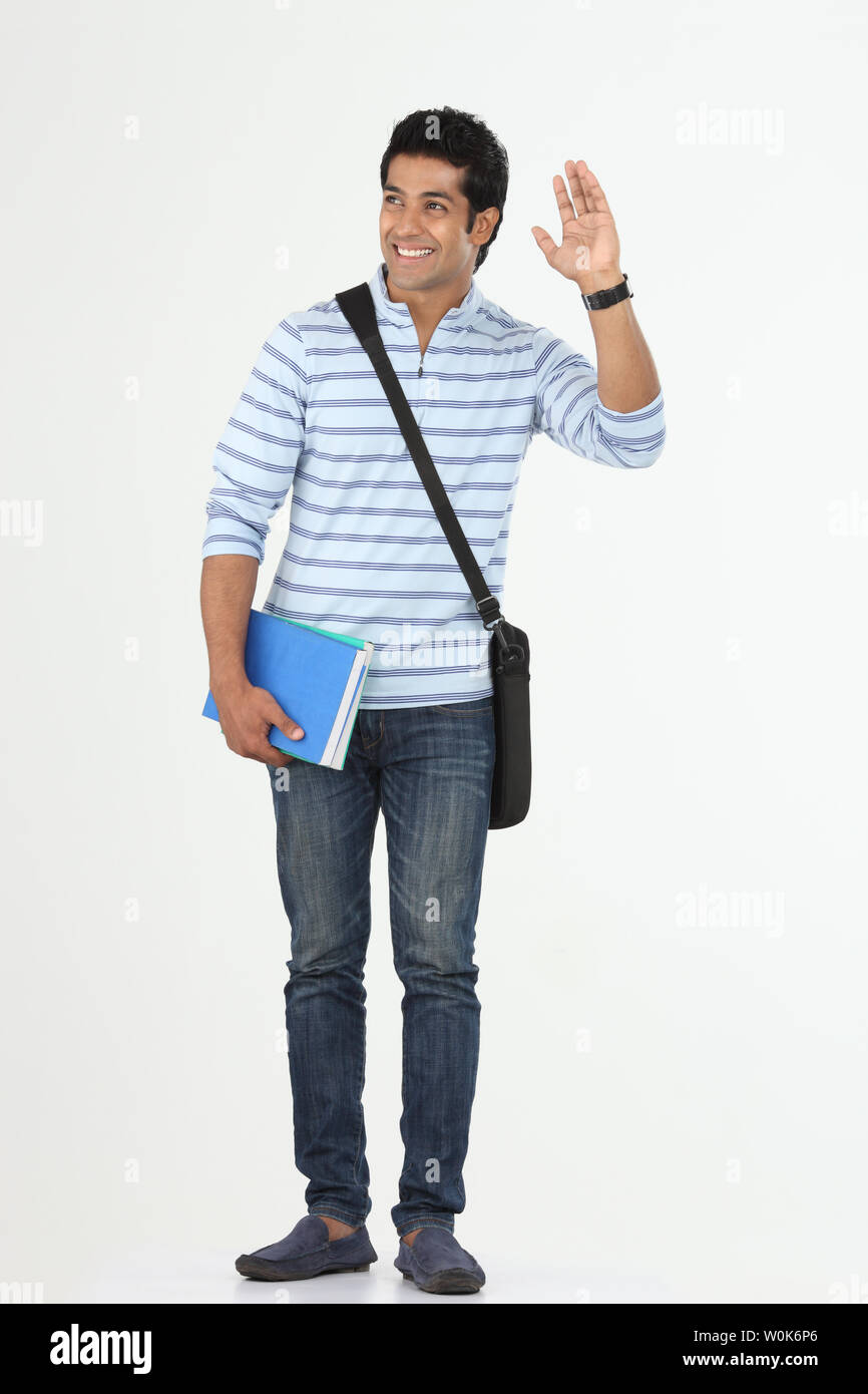 College student waving his hand and smiling Stock Photo - Alamy