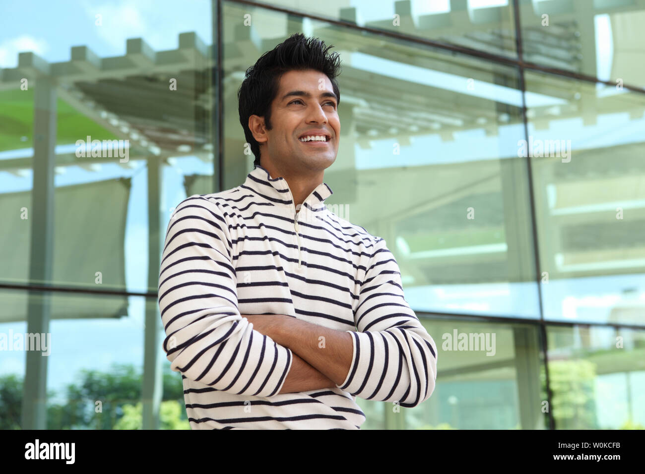 Indian man smiling with his arms crossed Stock Photo - Alamy