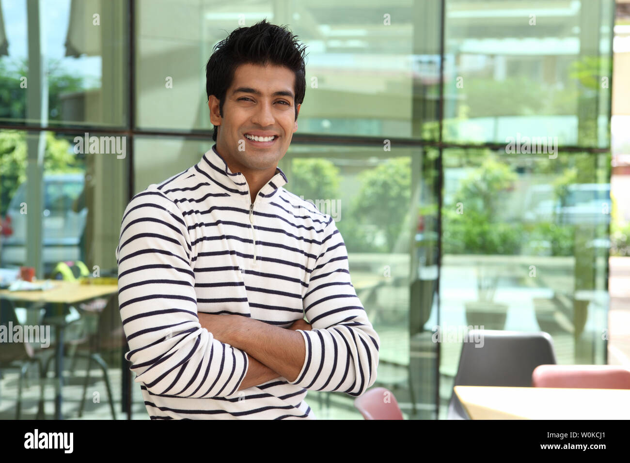 Man smiling with his arms crossed Stock Photo - Alamy
