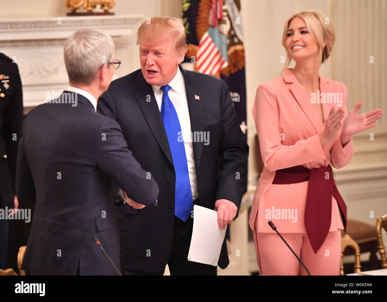 President Donald Trump greets CEO Tim Cook as his daughter Ivanka Trump ...