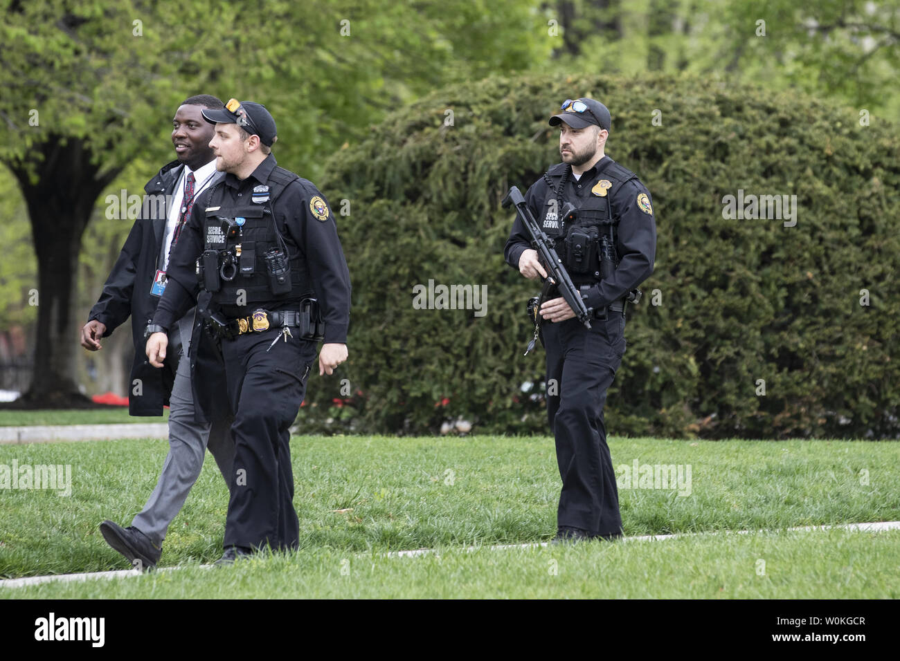 U.S. Secret Services officers walk on the White House grounds prior to clearing the White House ...
