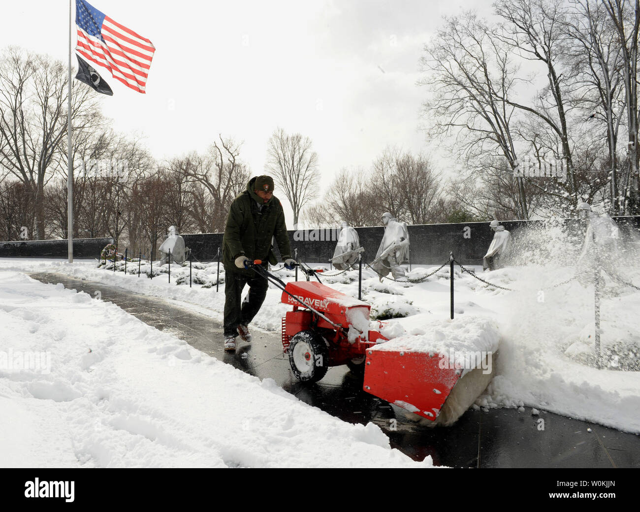 A National Park Service employee clears snow from the Korean War ...