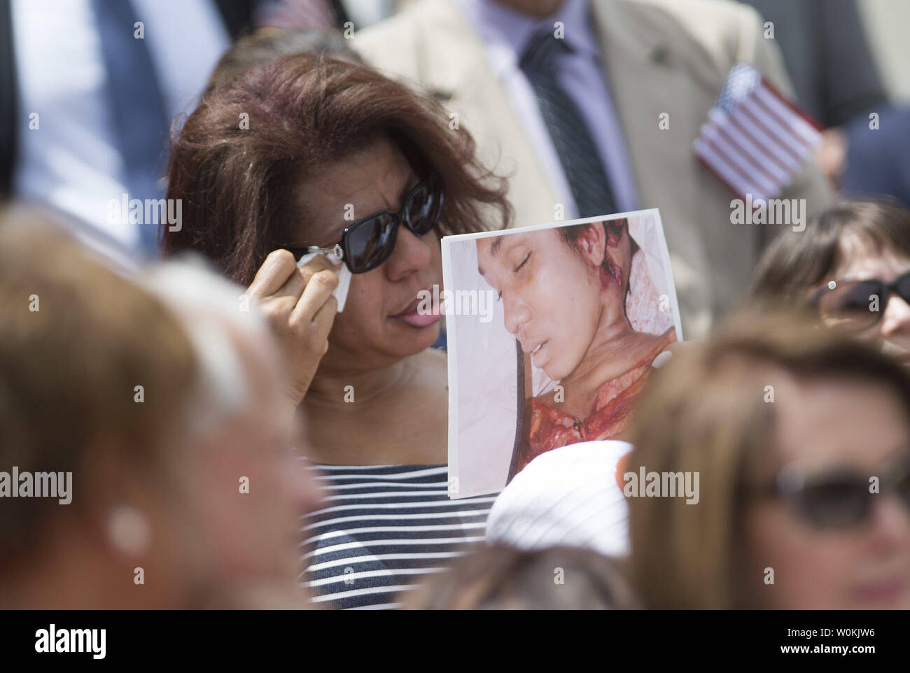 Nardyne Jefferies wipes tears as she holds a photo of her deceased ...