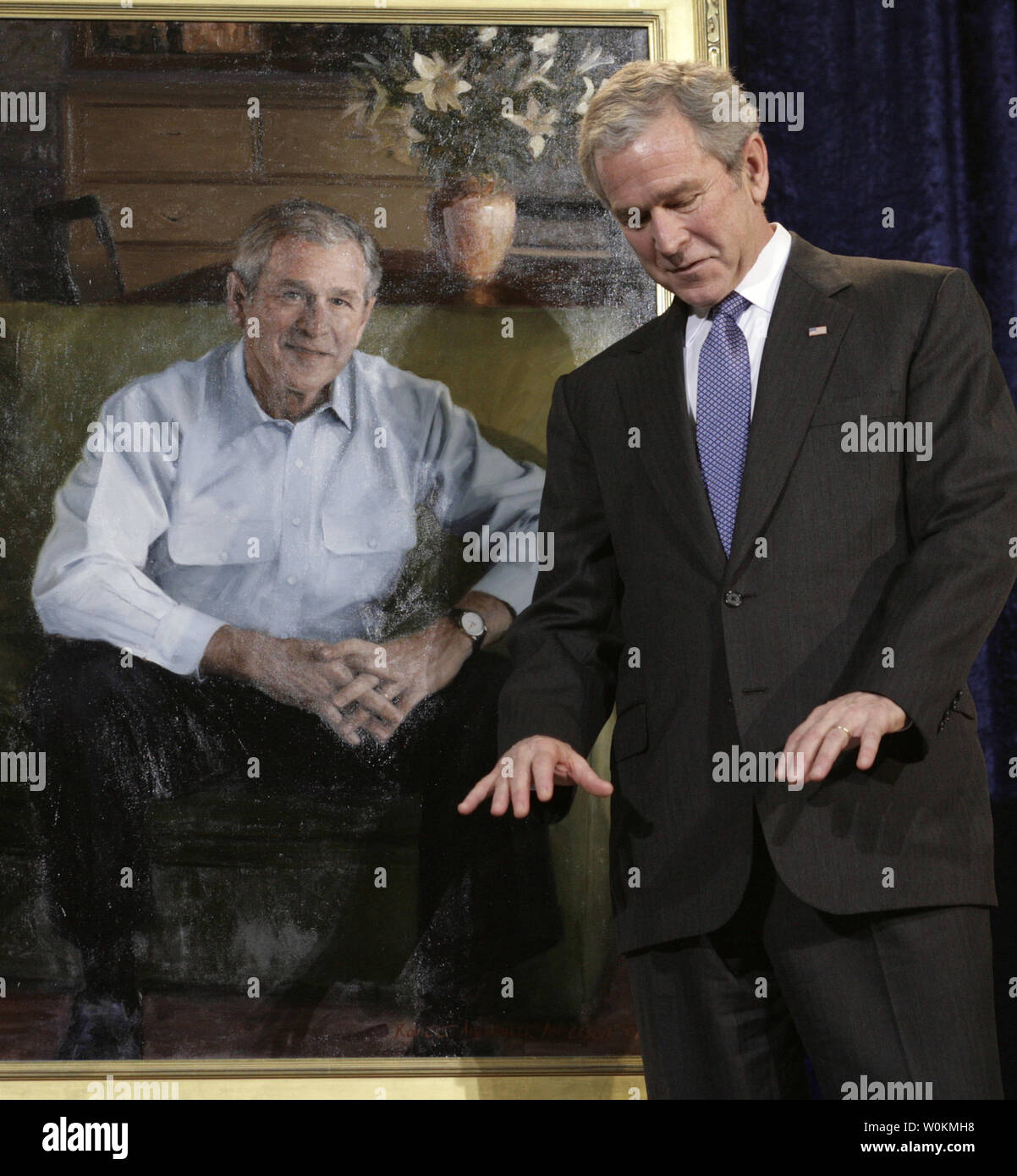 U.S. President George W. Bush stands next to his portrait during an ...