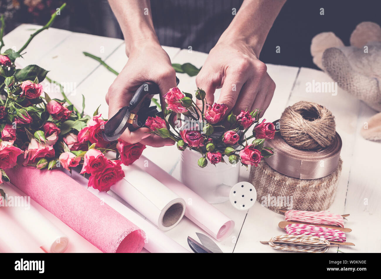 Florist at work. Female hands collect a wedding bouquet of roses. Small ...