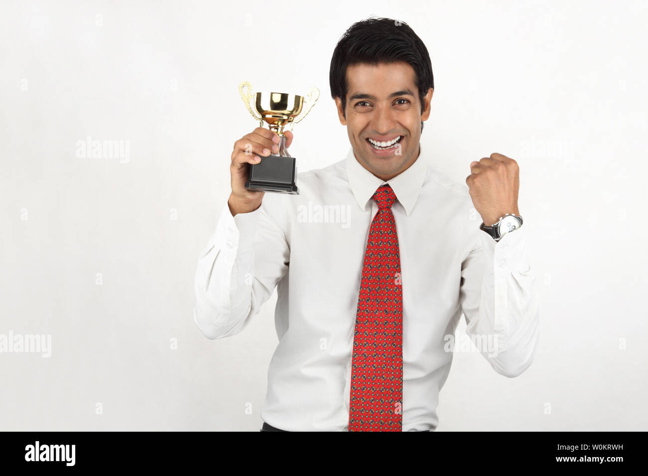 Businessman showing trophy and smiling Stock Photo - Alamy