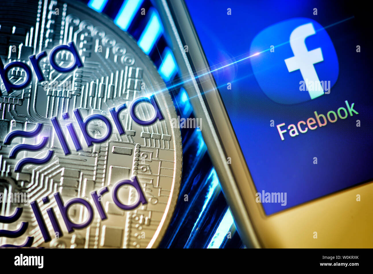 Facebook app on a smartphone screen and coin, libra cryptocurrency ...