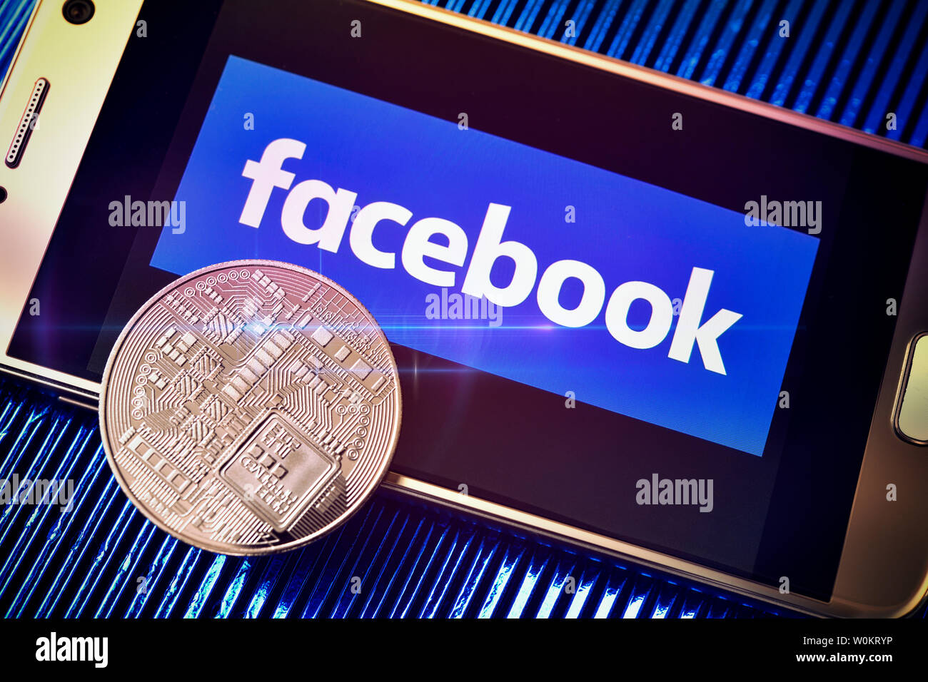 Facebook logo on a smartphone screen and coin, libra cryptocurrency ...