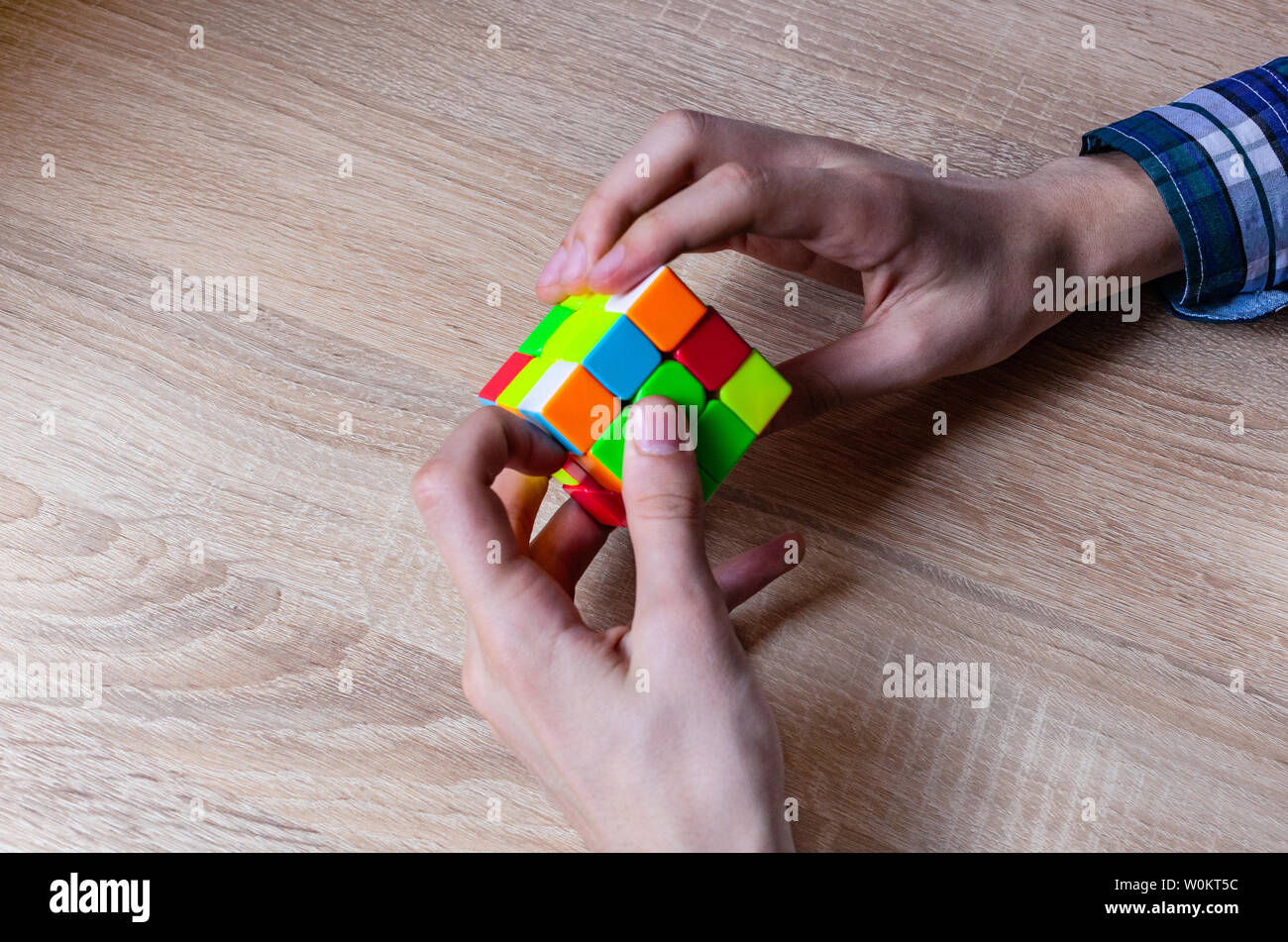 Young men holding Rubik's cube and playing with it. Rubik's cube in ...