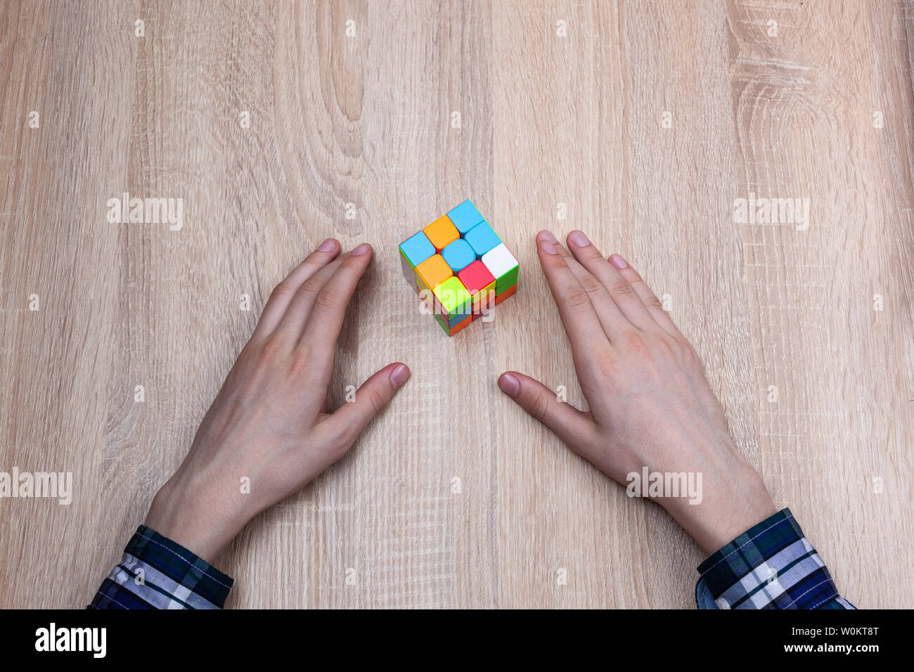 Young men holding Rubik's cube and playing with it. Rubik's cube in ...