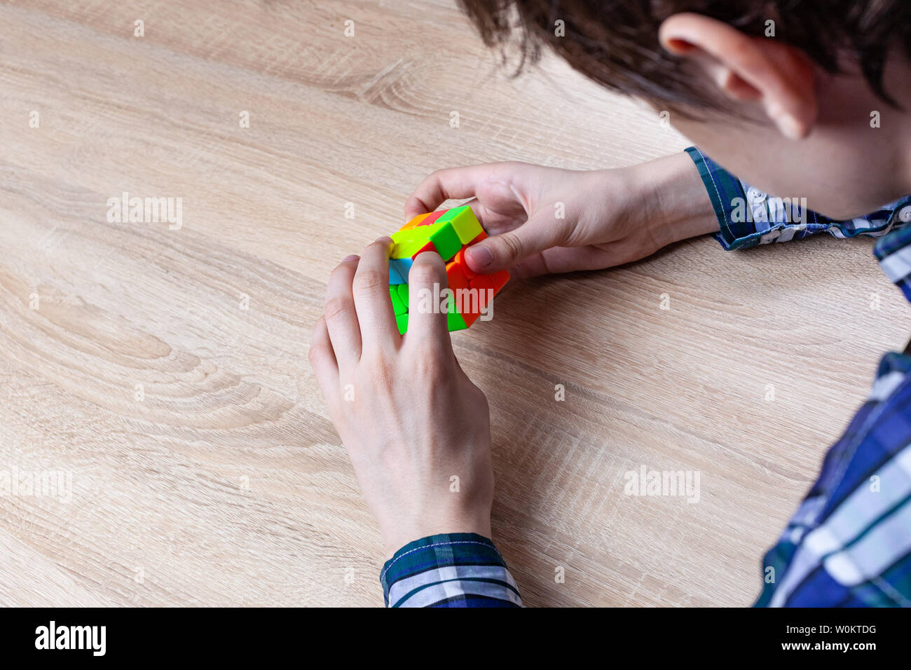 Young men holding Rubik's cube and playing with it. Rubik's cube in ...