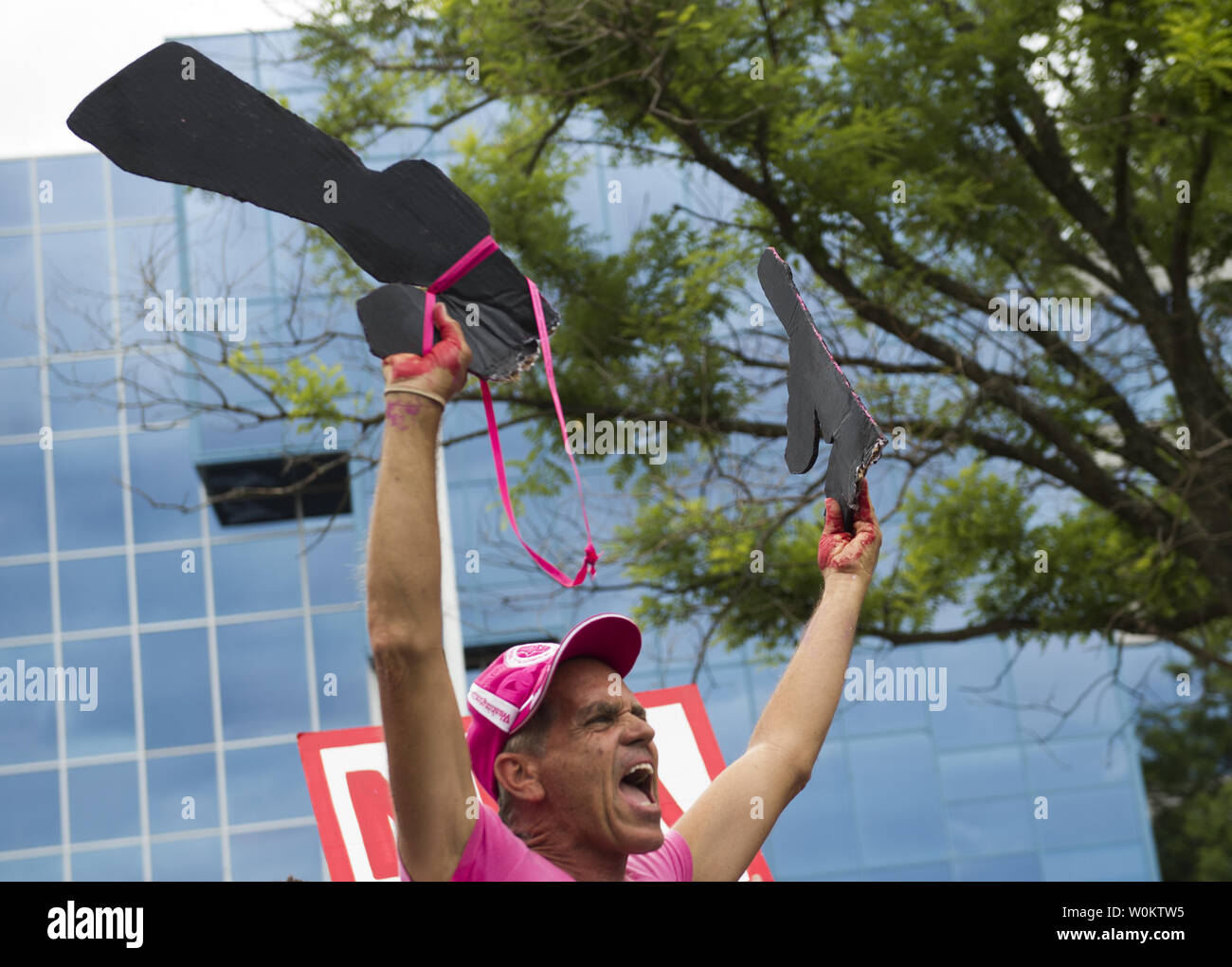 A Code Pink protester breaks a cardboard weapon during a protest ...