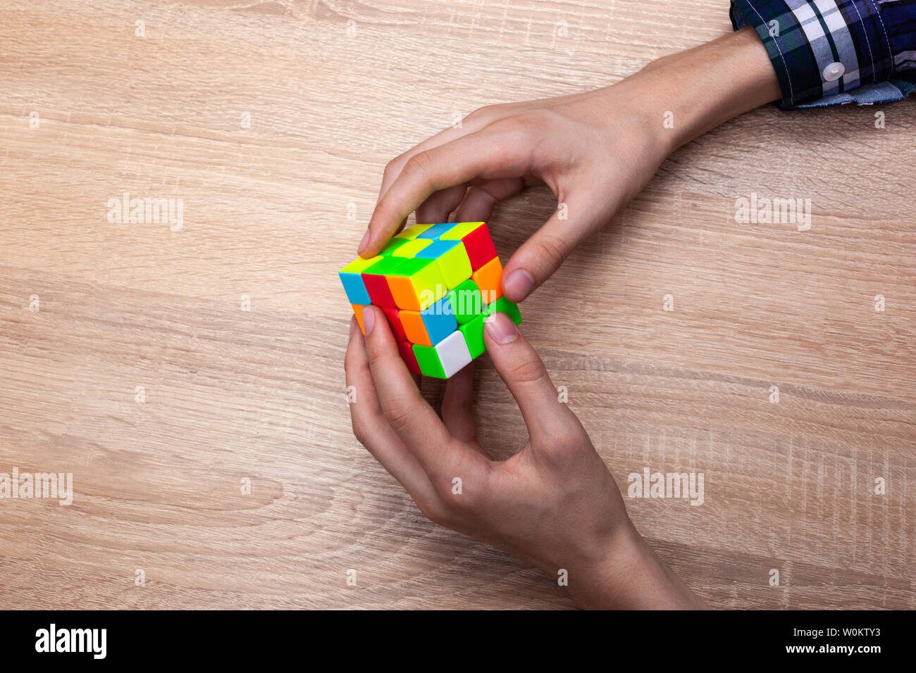 Young men holding Rubik's cube and playing with it. Rubik's cube in ...