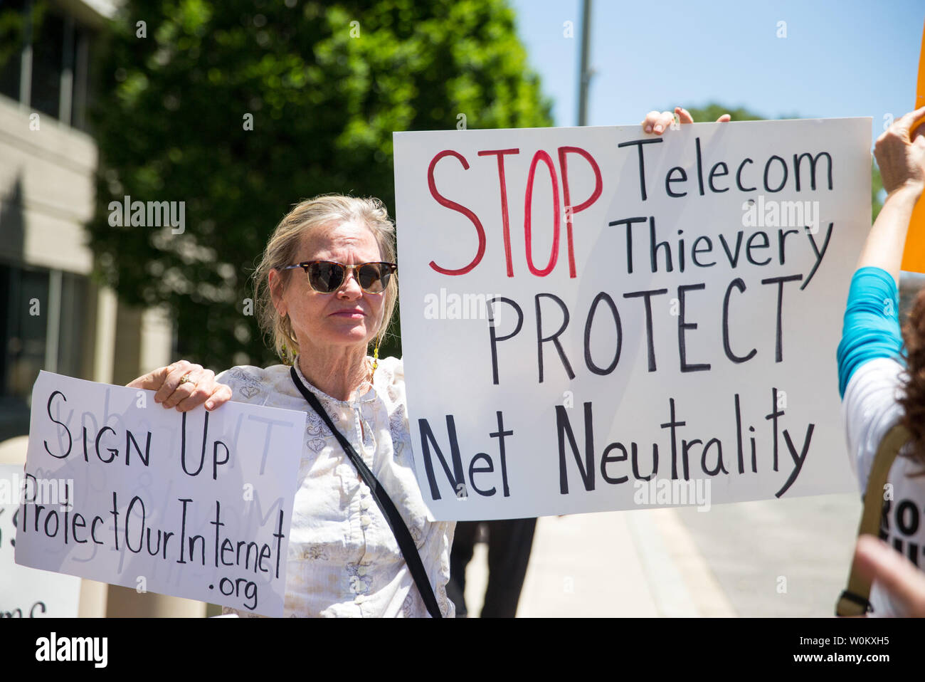 Demonstrators Marie Murphy holds up signs at a protest held by net ...