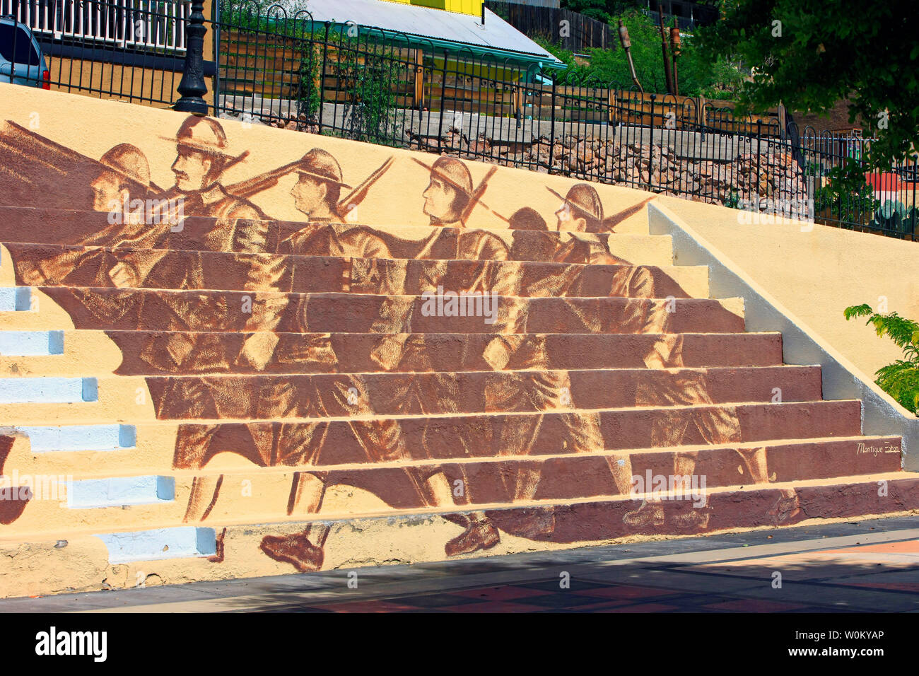 Painted mural of miners and soldiers from past times on the seating at ...