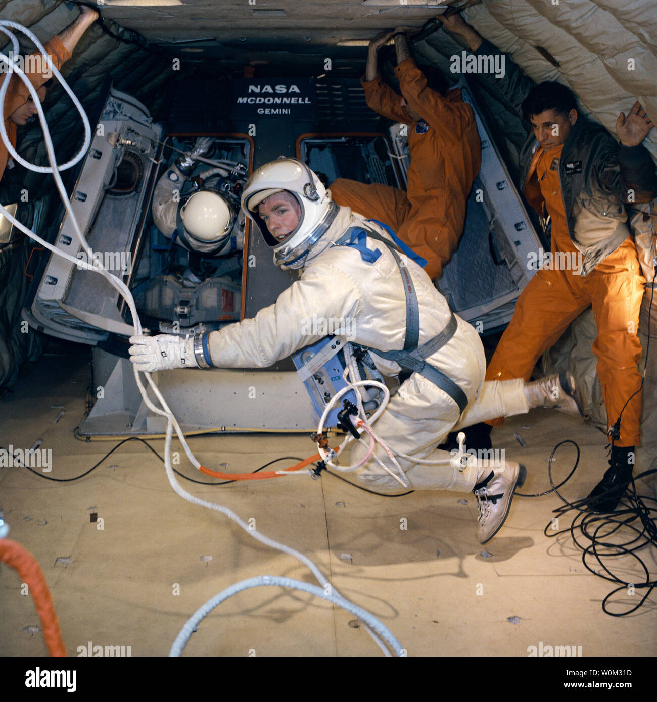 NASA astronaut David Scott, in full spacesuit, holds onto the ...