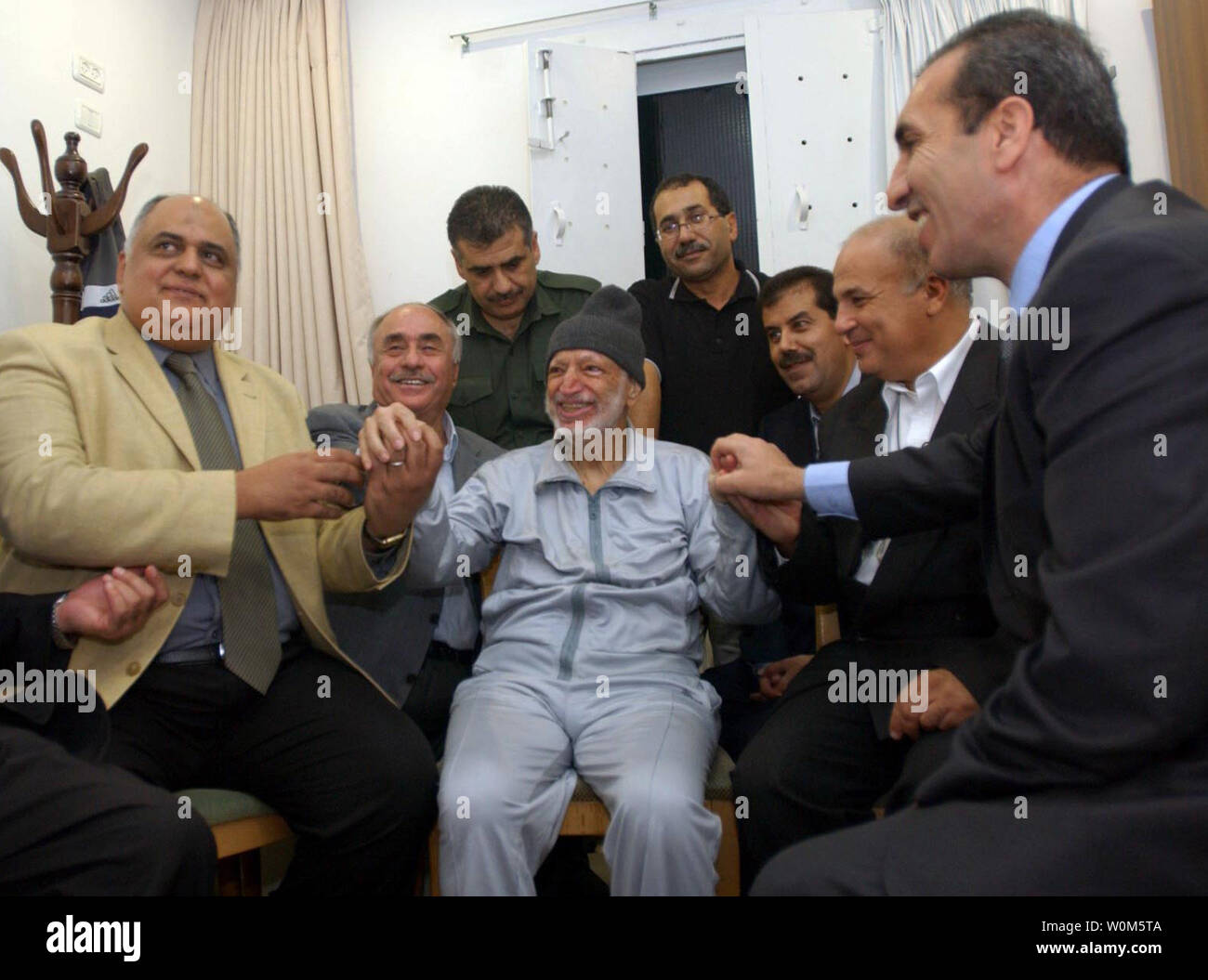 Palestinian leader Yasser Arafat holds hands with unidentified ...