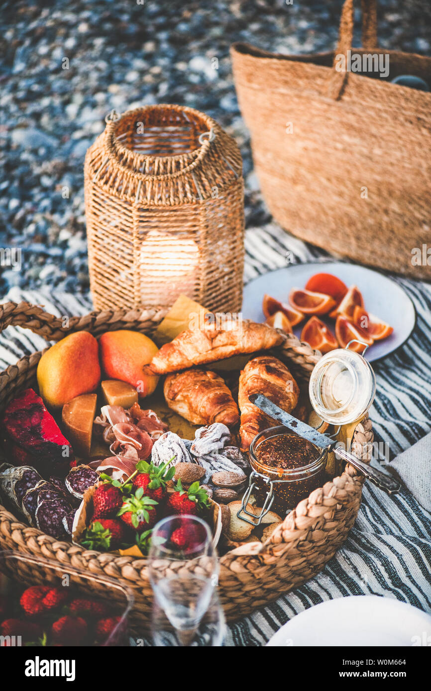 Summer picnic concept with tasty appetizers, fruits and croissants ...