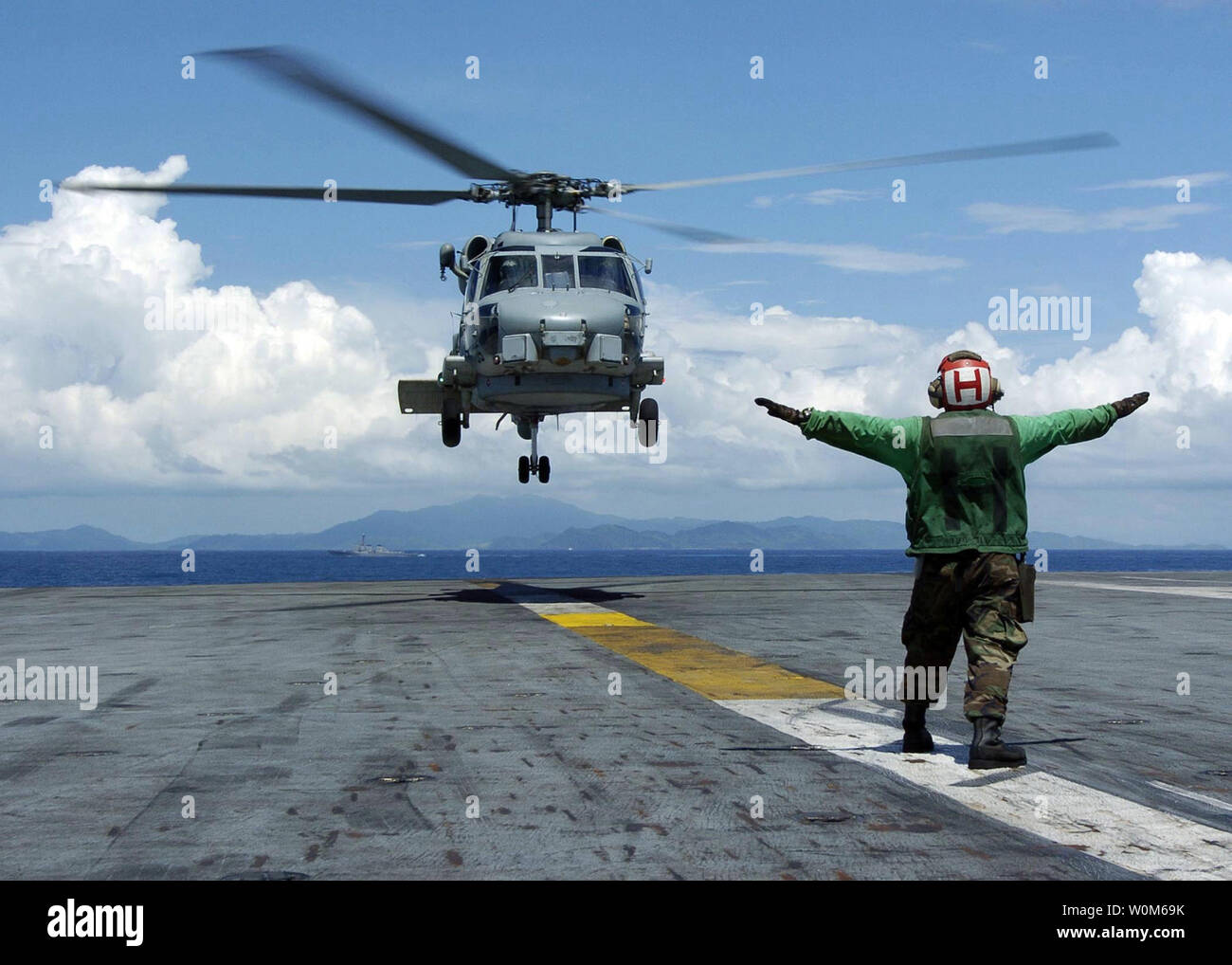 A Landing Signals Enlisted man directs an SH-60B Seahawk helicopter ...