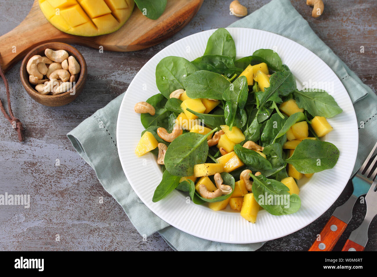 Diet menu, Vegan food. Healthy salad with spinach, mango, pecan and ...