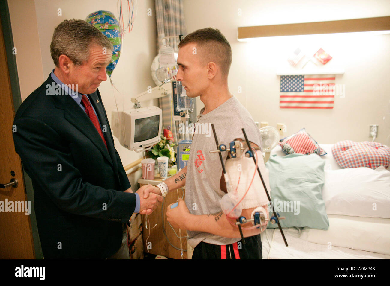 President George W. Bush shakes the hand of Marine Cpl. Anthony Gower ...