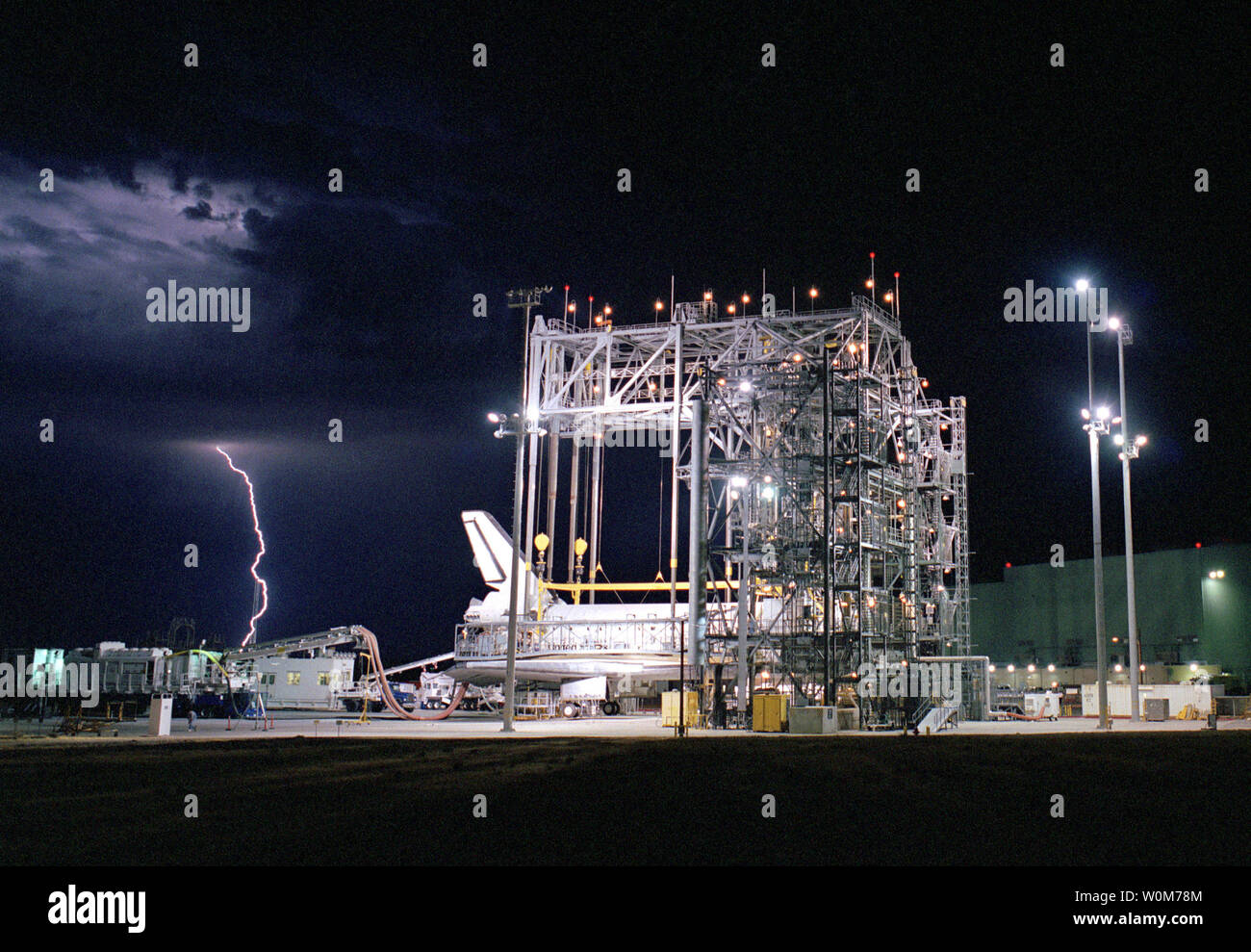 Lightning strikes in the distance as the Space Shuttle Discovery goes ...