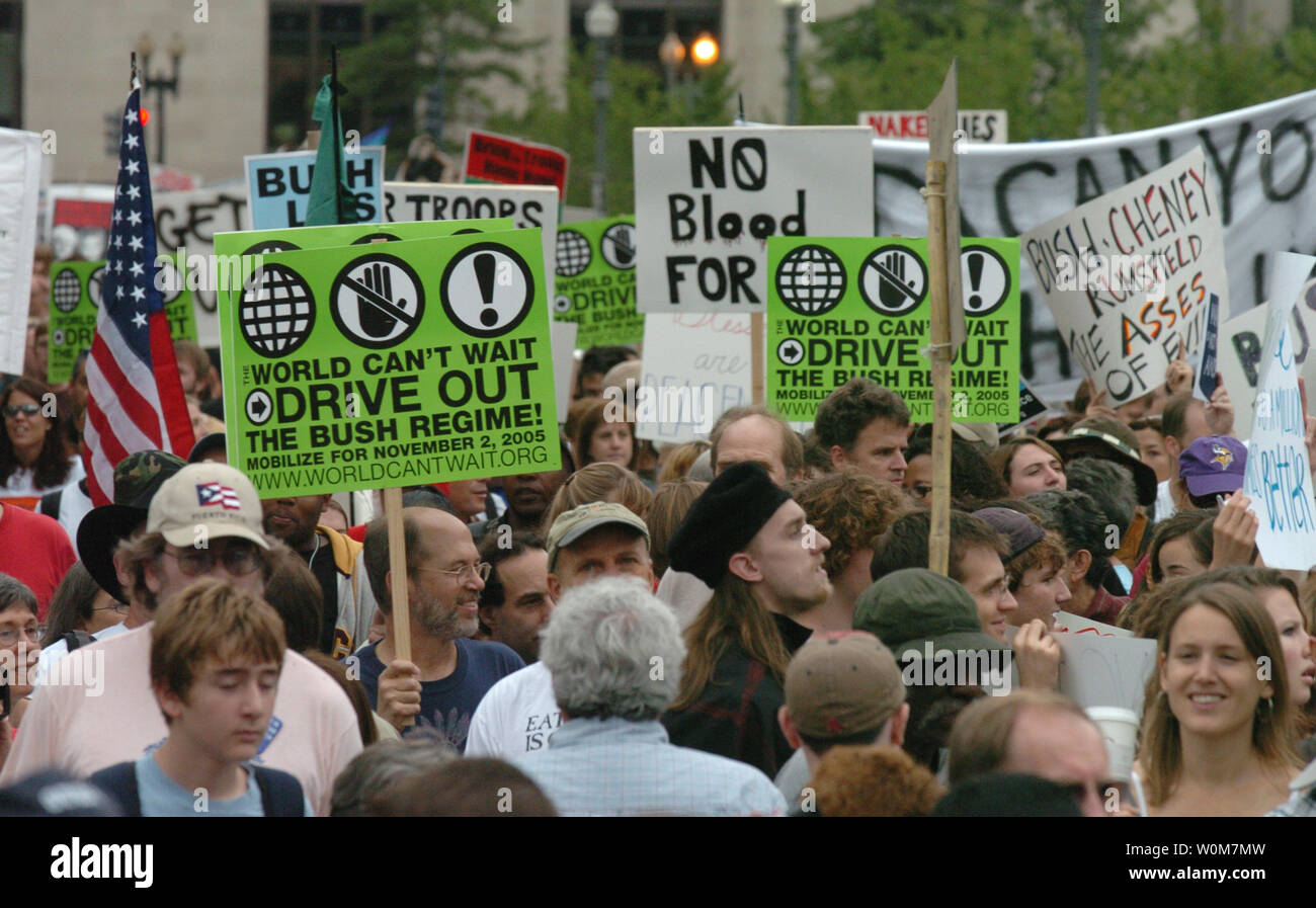 Demonstrators carry signs as they march in a massive anti-war protest ...