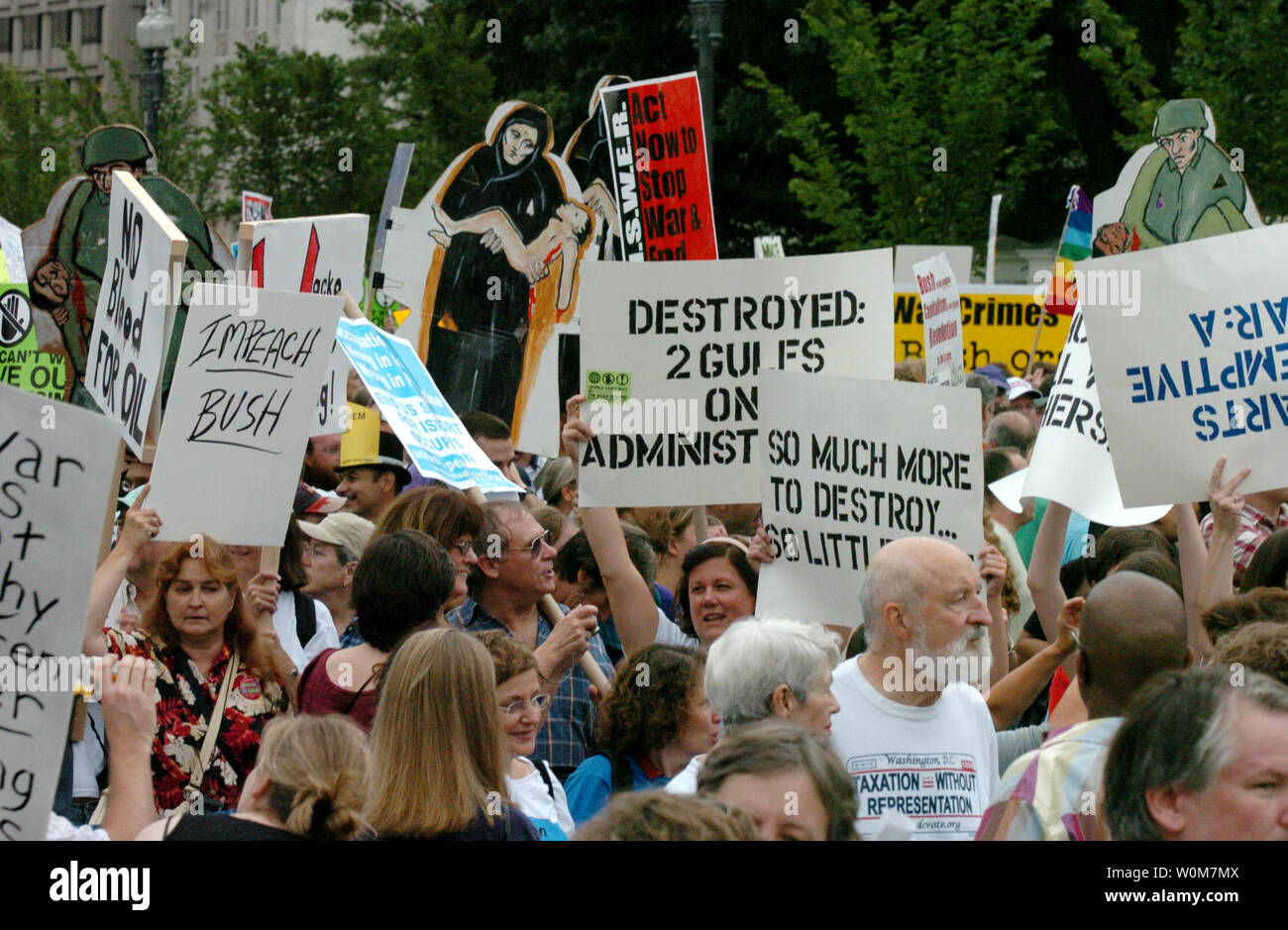 Demonstrators carry signs as they march in a massive anti-war protest ...