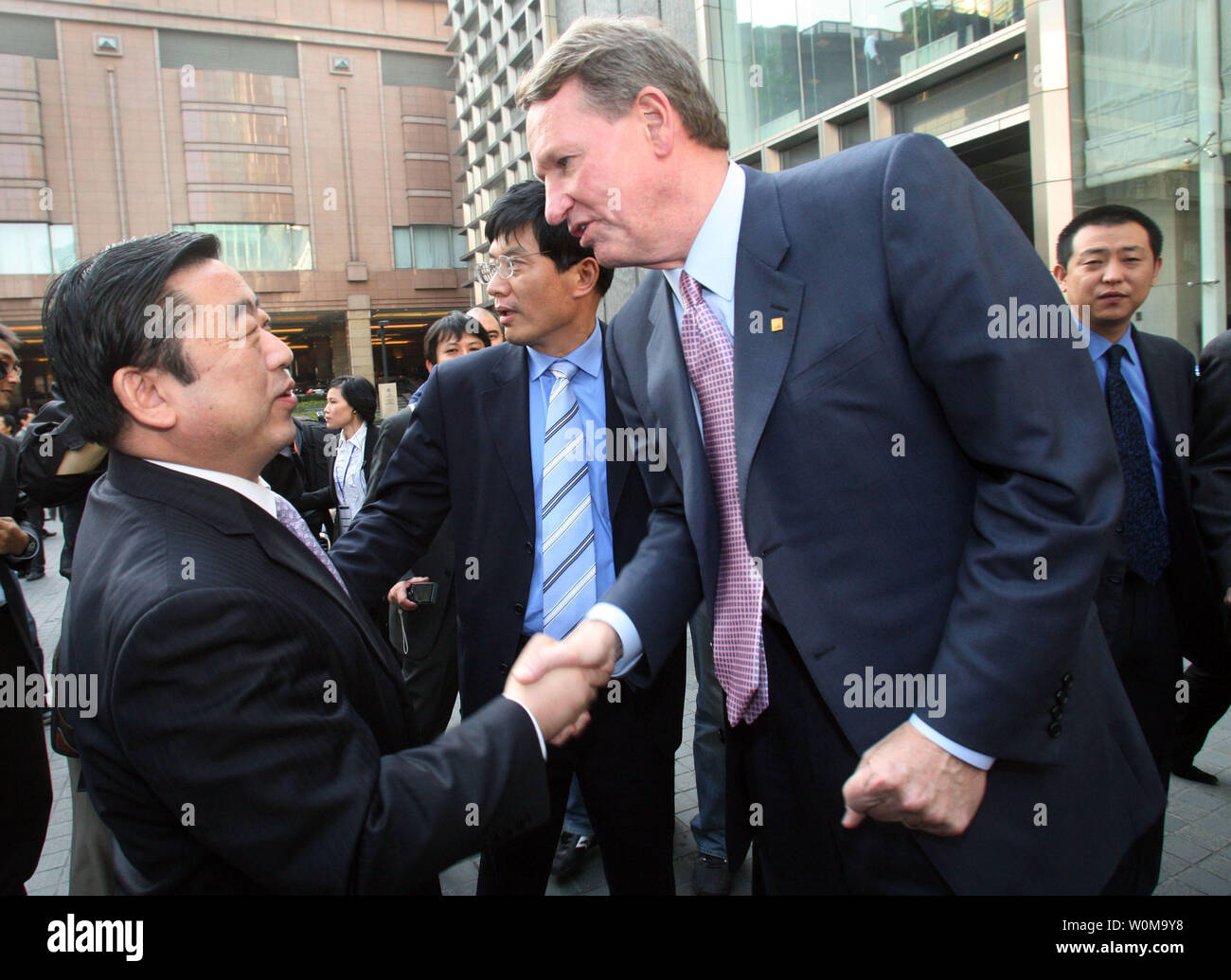 SAIC Chairman Hu Maoyuan (left) shakes hands with General Motors ...
