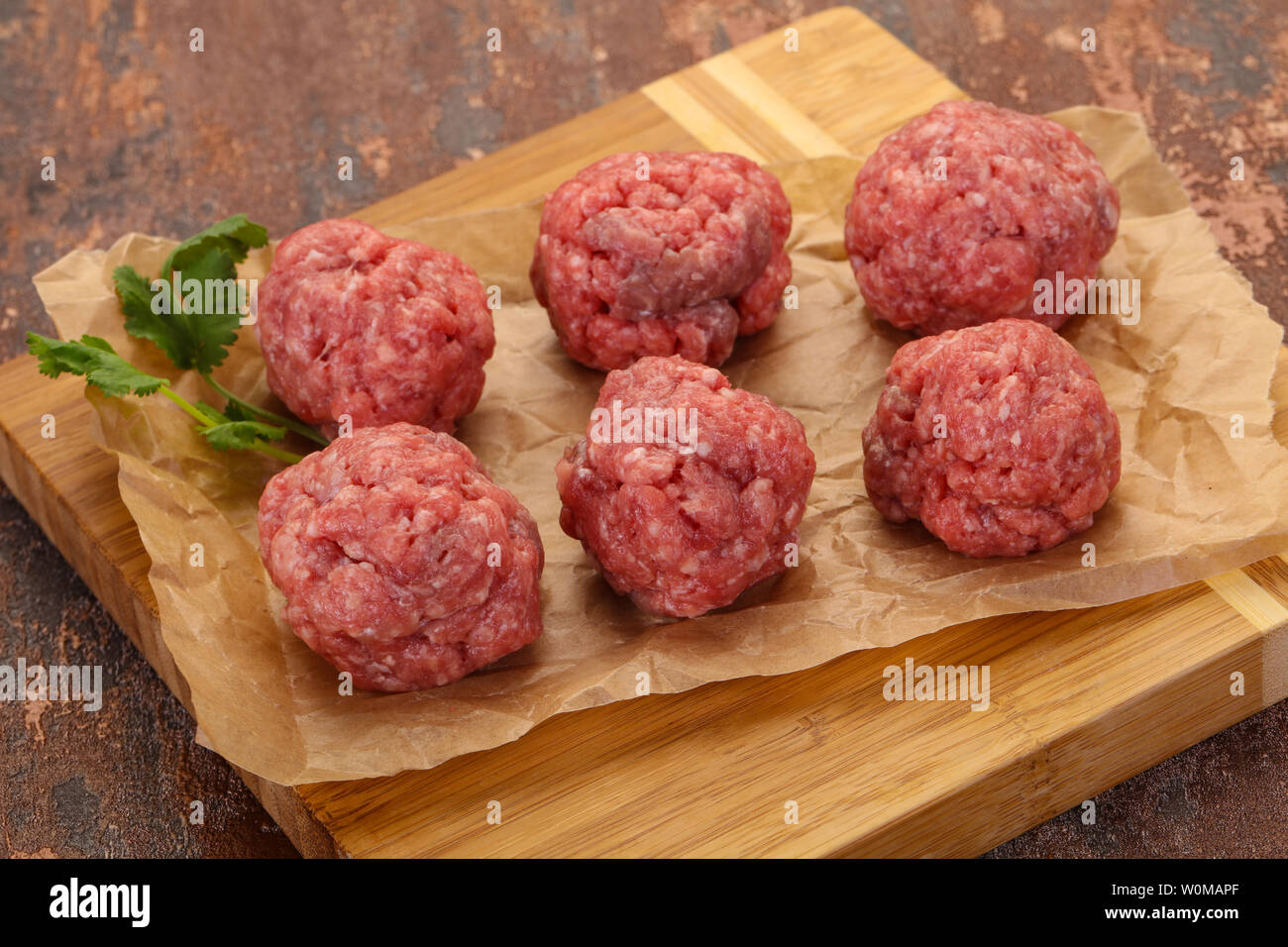 Raw meatball over wooden background ready for cooking Stock Photo - Alamy