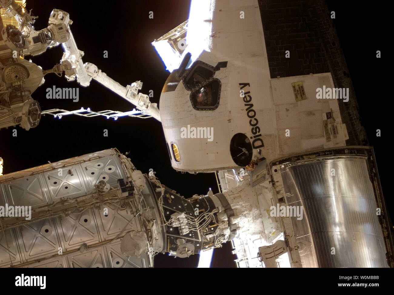 The Space Shuttle Discovery is seen docked to the Pressurized Mating ...