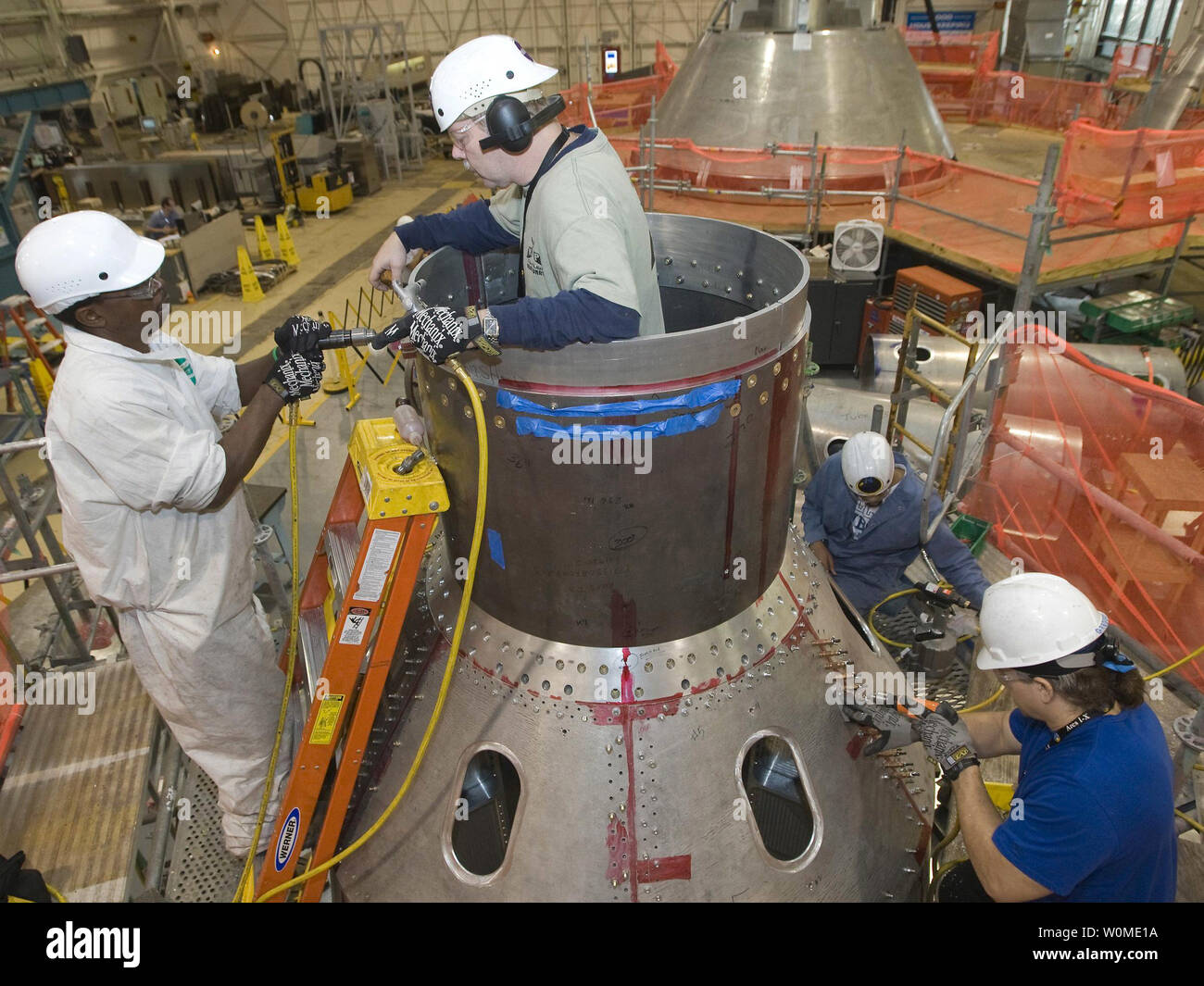 This undated NASA image shows technicians working on the crew module ...