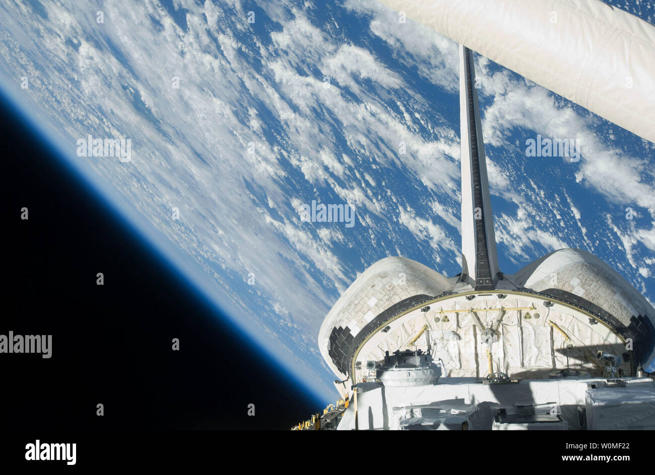 Backdropped by a blue and white Earth and the blackness of space, a ...