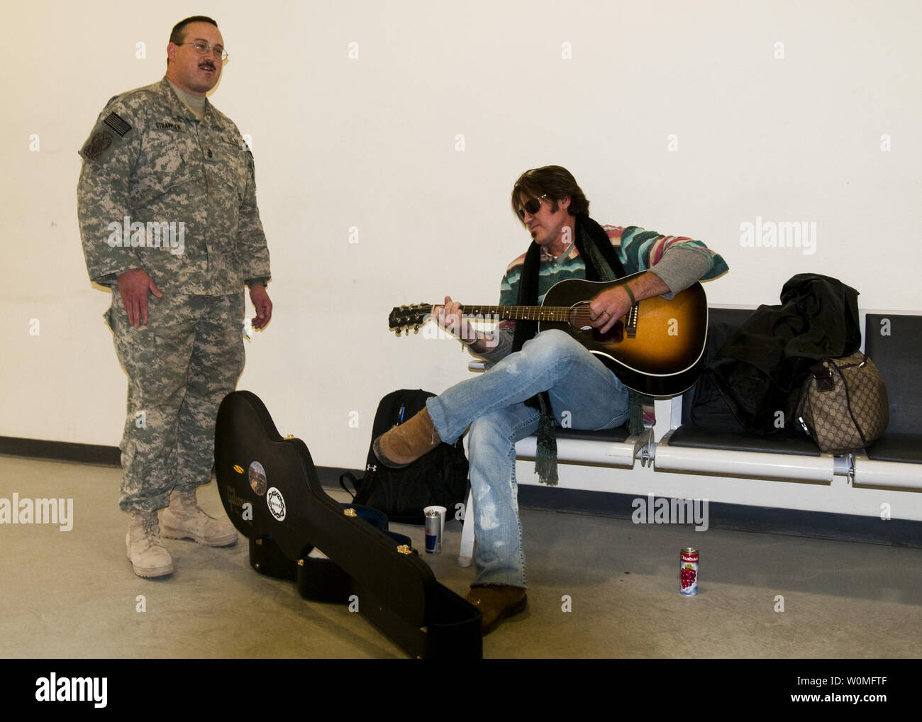 U.S. Navy Chief Petty Officer Craig Strawser sings a song with singer ...