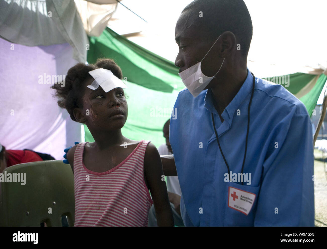 Red Cross volunteer Jean Baptiste Kostner gives medical attention to ...