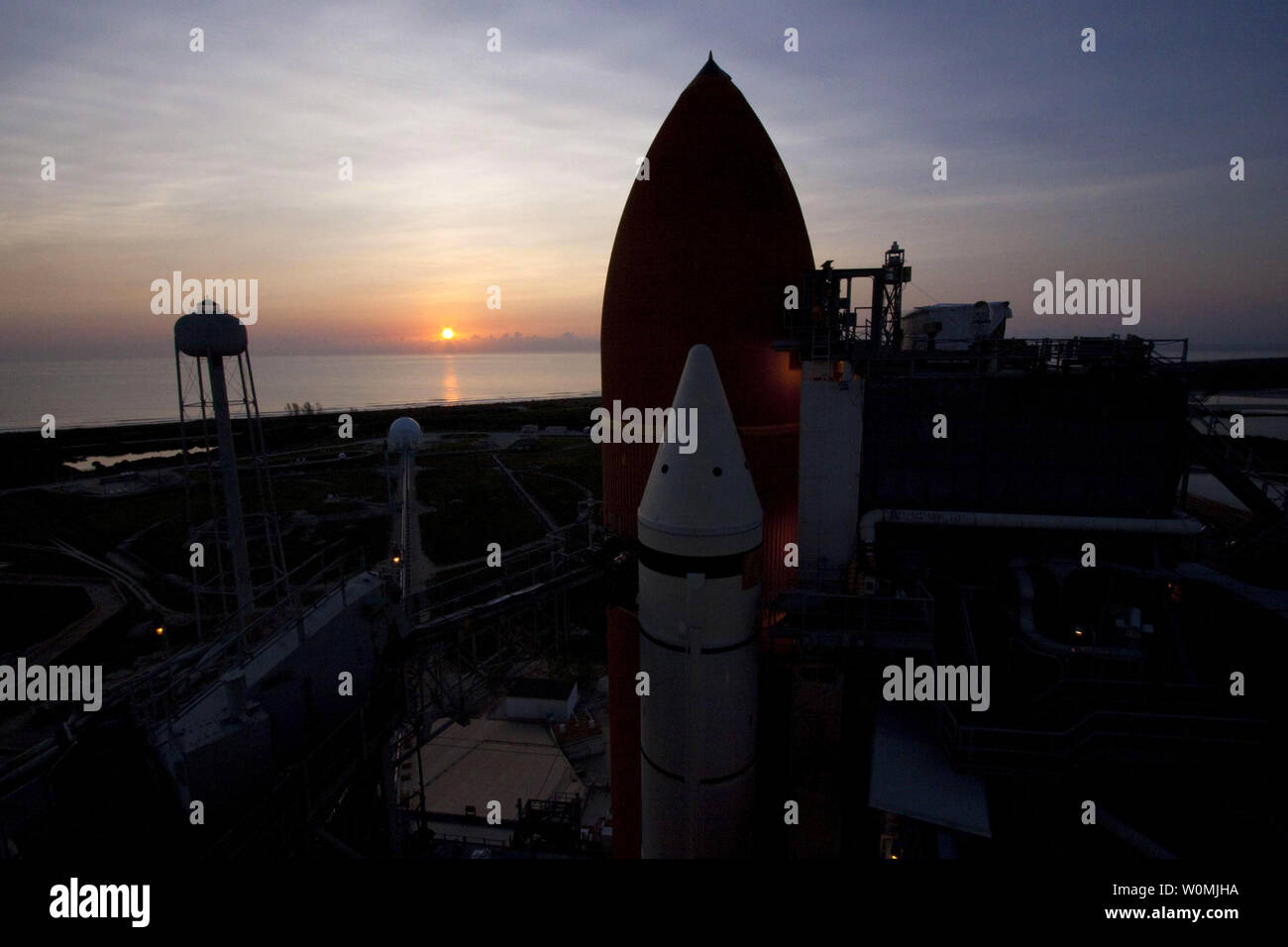 The sun rises over the Atlantic Ocean silhouetting space shuttle ...