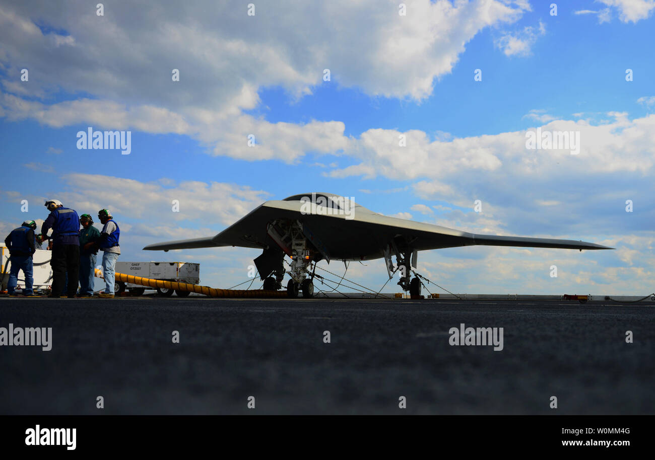 An X-47B Unmanned Combat Air System (UCAS) demonstrator is towed into ...