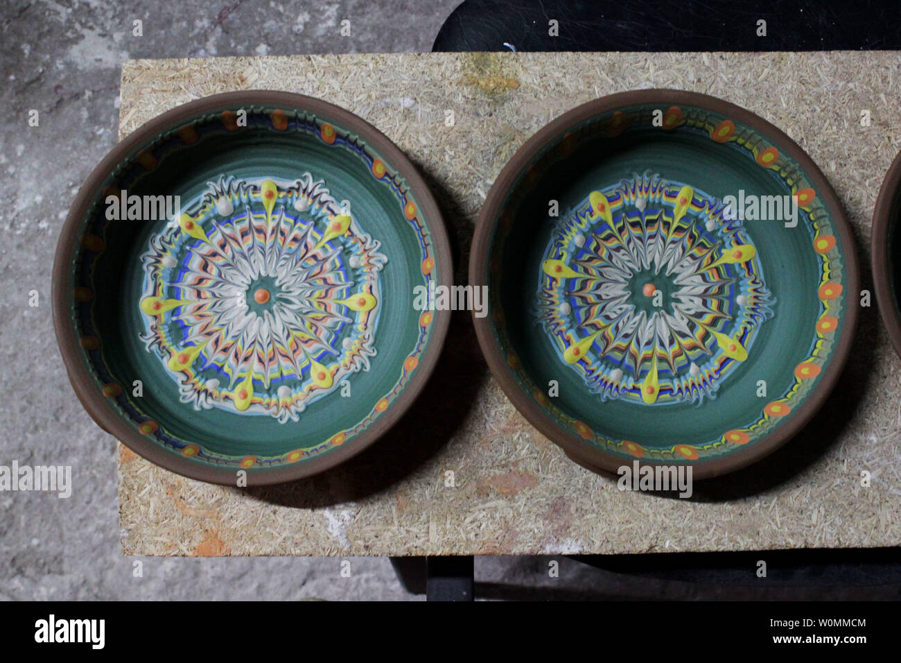 large plates decorates a clay plate made on a pottery wheel using ...
