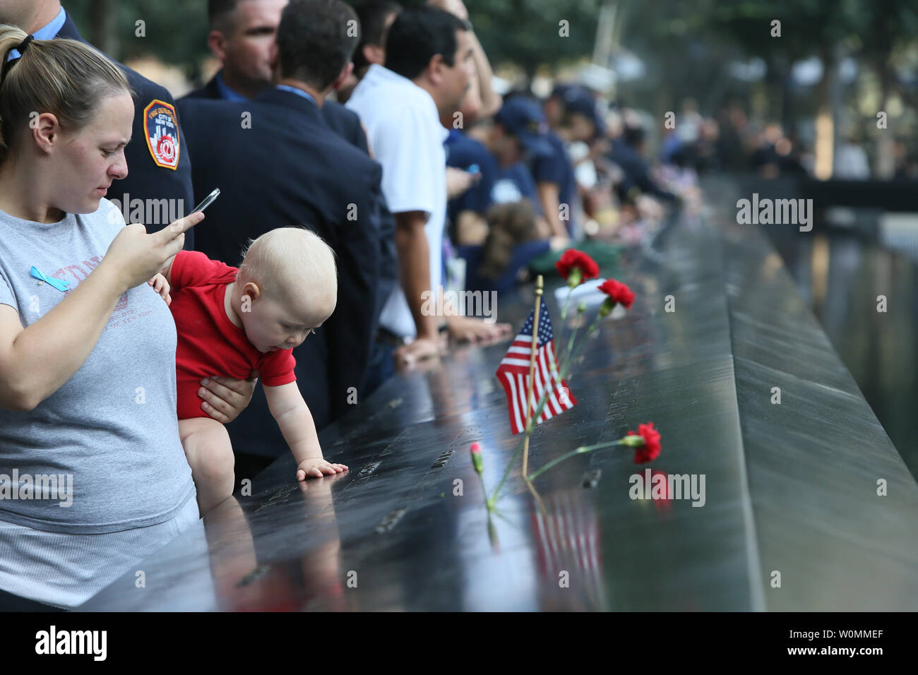 Melissa Rohrig takes a picture of the name of her father, firefighter ...