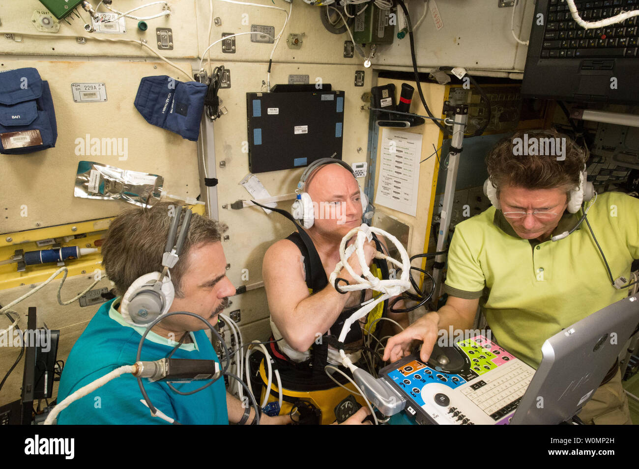 NASA astronaut Scott Kelly, center, takes medical measurements as part ...