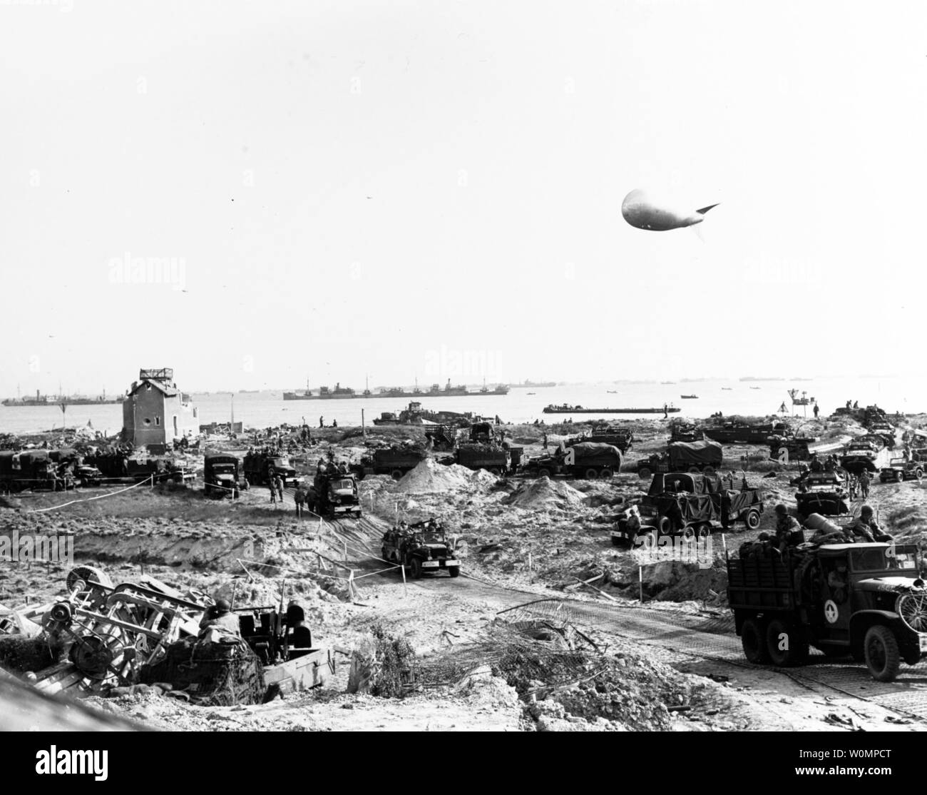 U.S. Army trucks move inland from Omaha Beach, soon after the Allied invasion of German-occupied ...