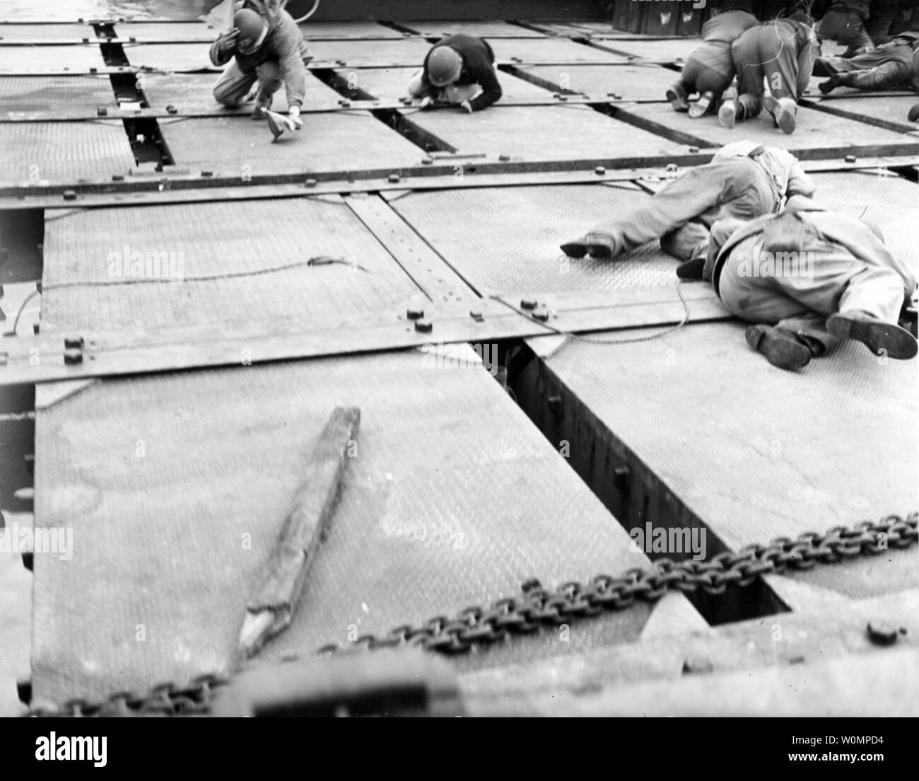 U.S. Navy sailors on a Rhino (RHF) pontoon barge duck to avoid strafing ...
