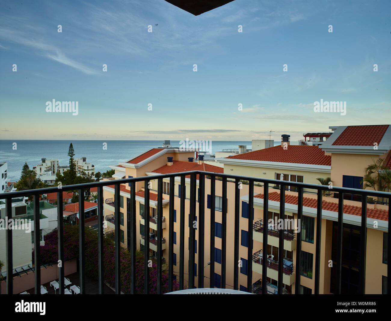 View across Madeiran rooftops with balcony railings towards the North ...
