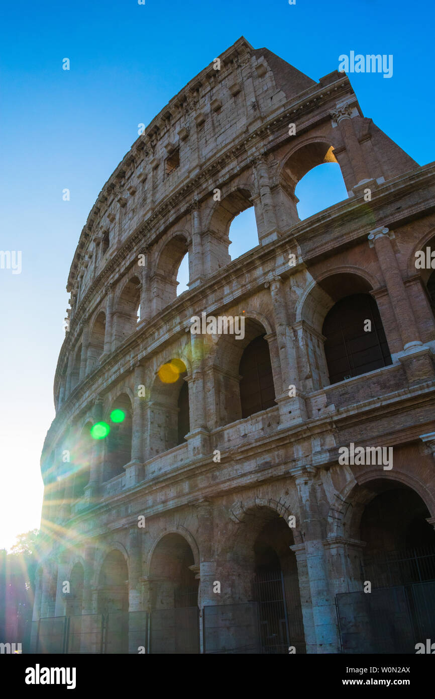 Roman Colosseum, with sun lights and blue sky. Summer time, travel ...