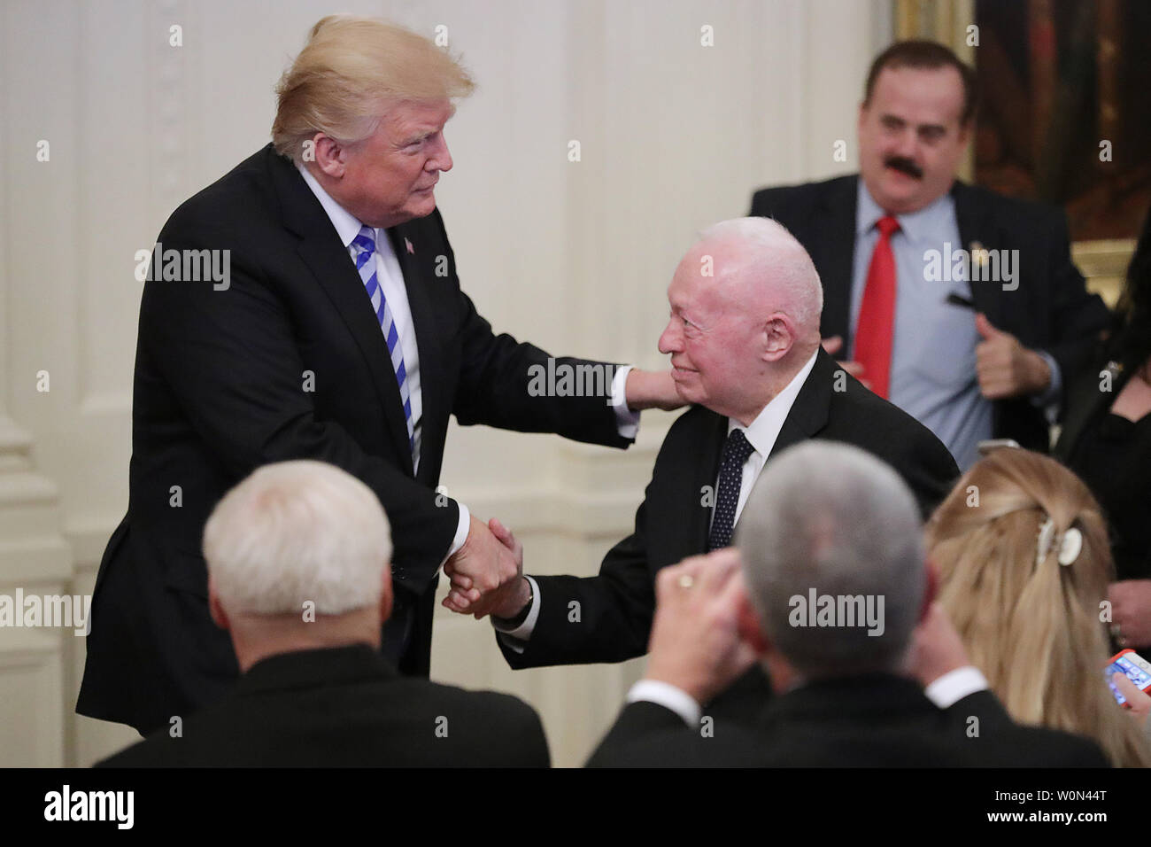 U.S. President Donald Trump shakes hands with former Commandant of the ...